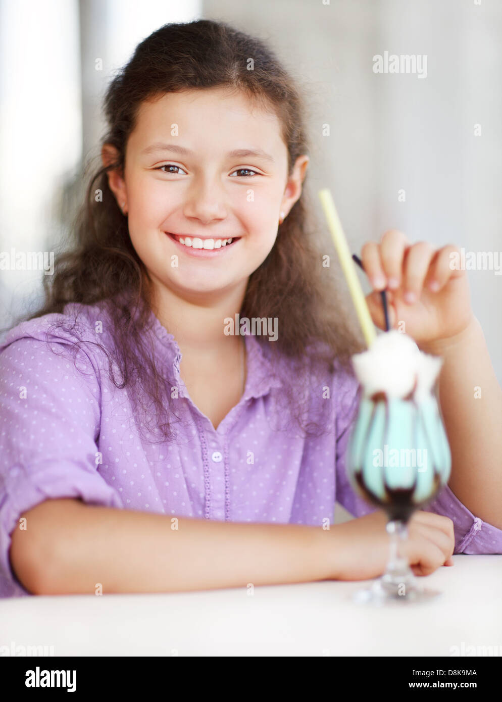 Happy little cute girl drinking shake Stock Photo - Alamy