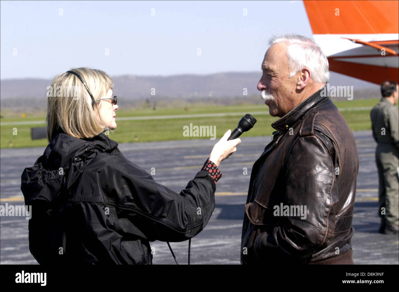 This image shows a TV reporter conducting an interview. The reporter is ...