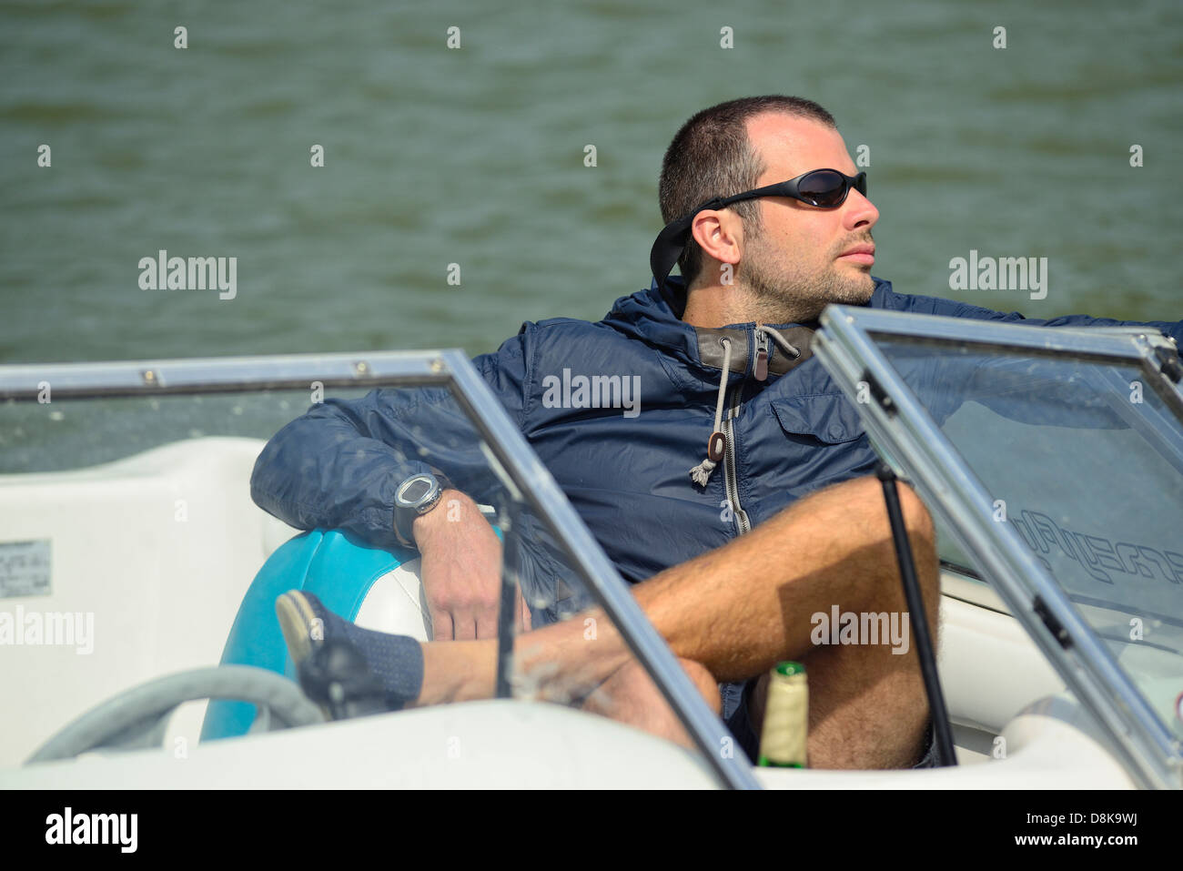 Man sitting in a motorboat looking away Stock Photo - Alamy