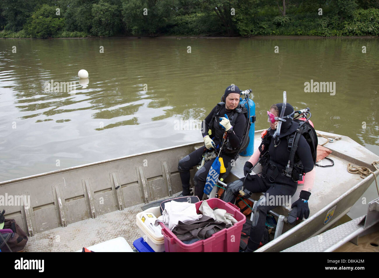 Two scuba divers communicate before descending into the water ...