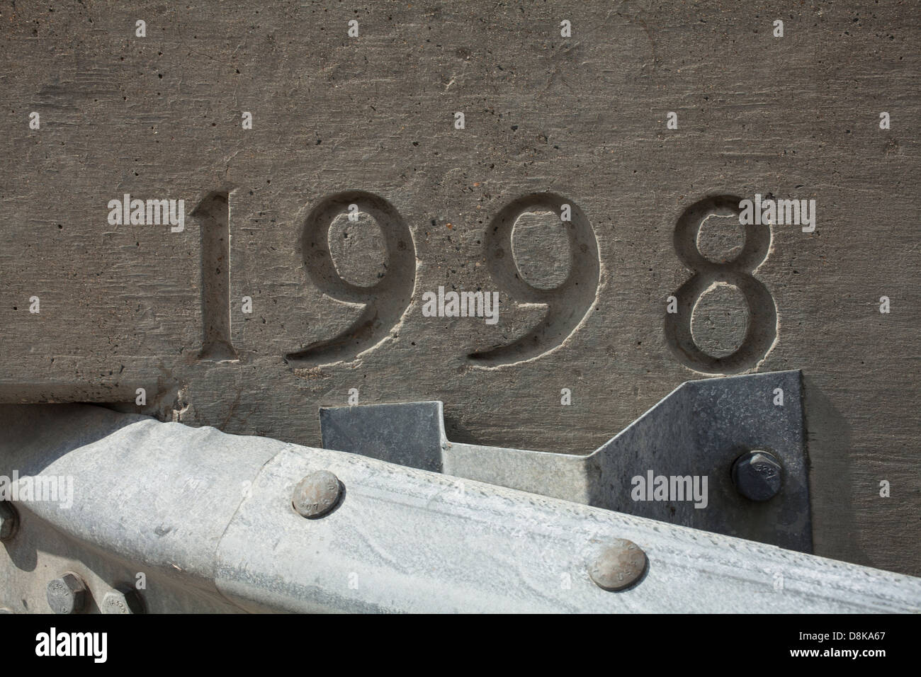 The date of the building of a small bridge is set in cement, behind ...