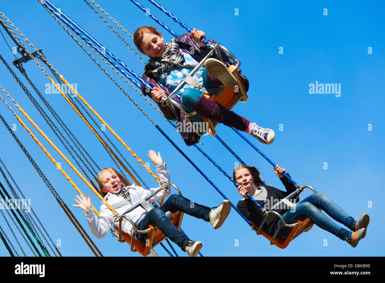 Teenage girls on the chain swing carousel Stock Photo - Alamy