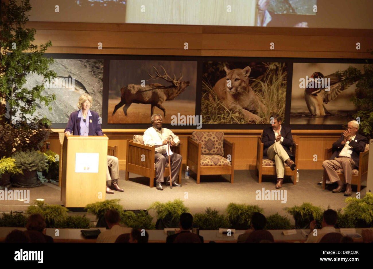 A woman speaking at a podium during a summit, addressing the audience ...