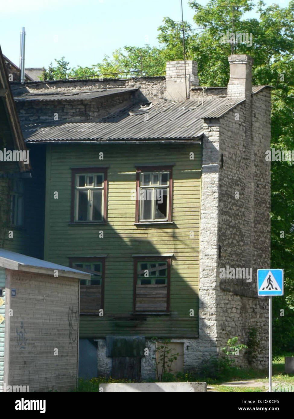 A worn house showing signs of age and weathering. The exterior displays peeling paint, cracked ...