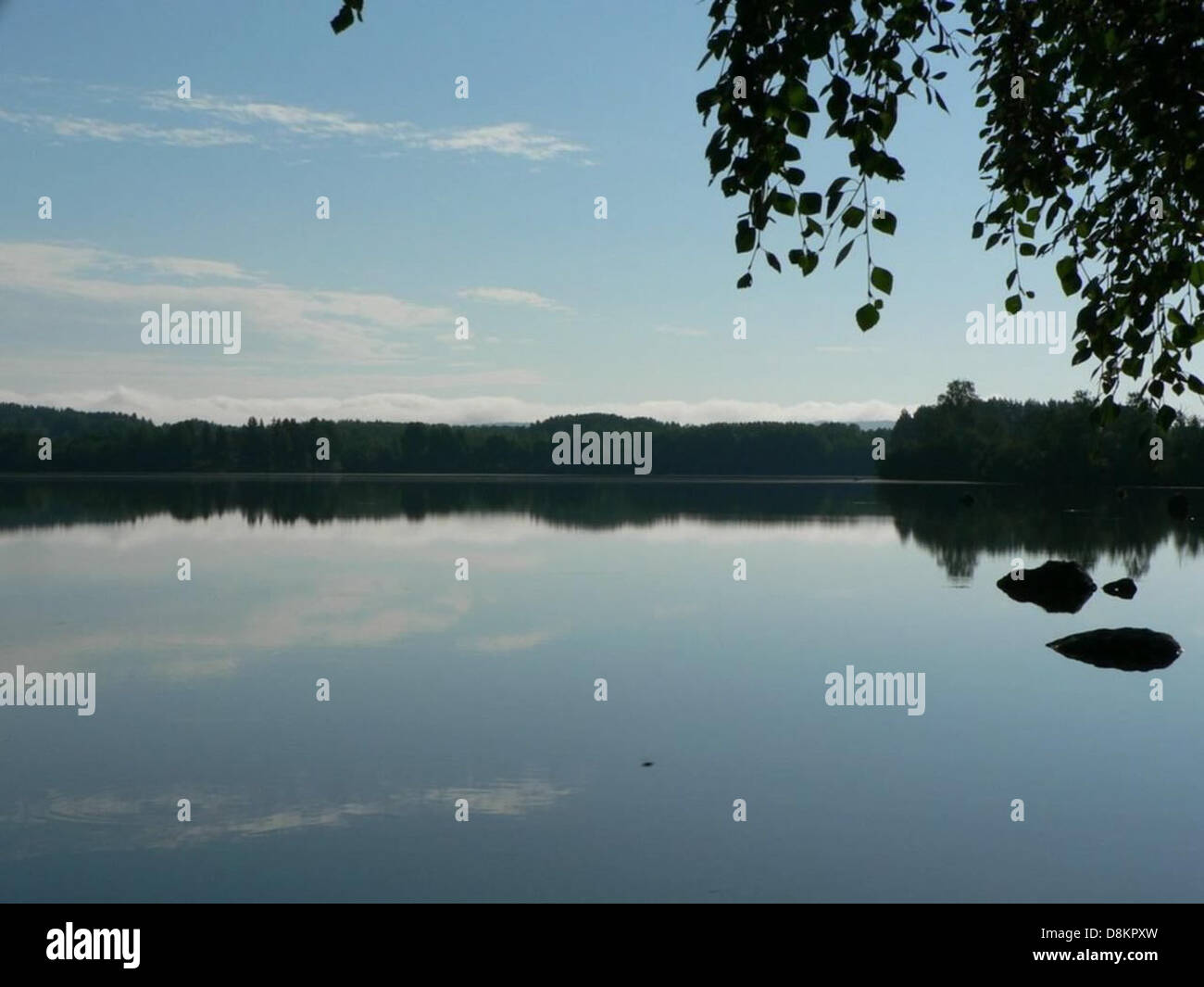 A serene scene of a mirror-like lake reflecting the colorful sky after ...