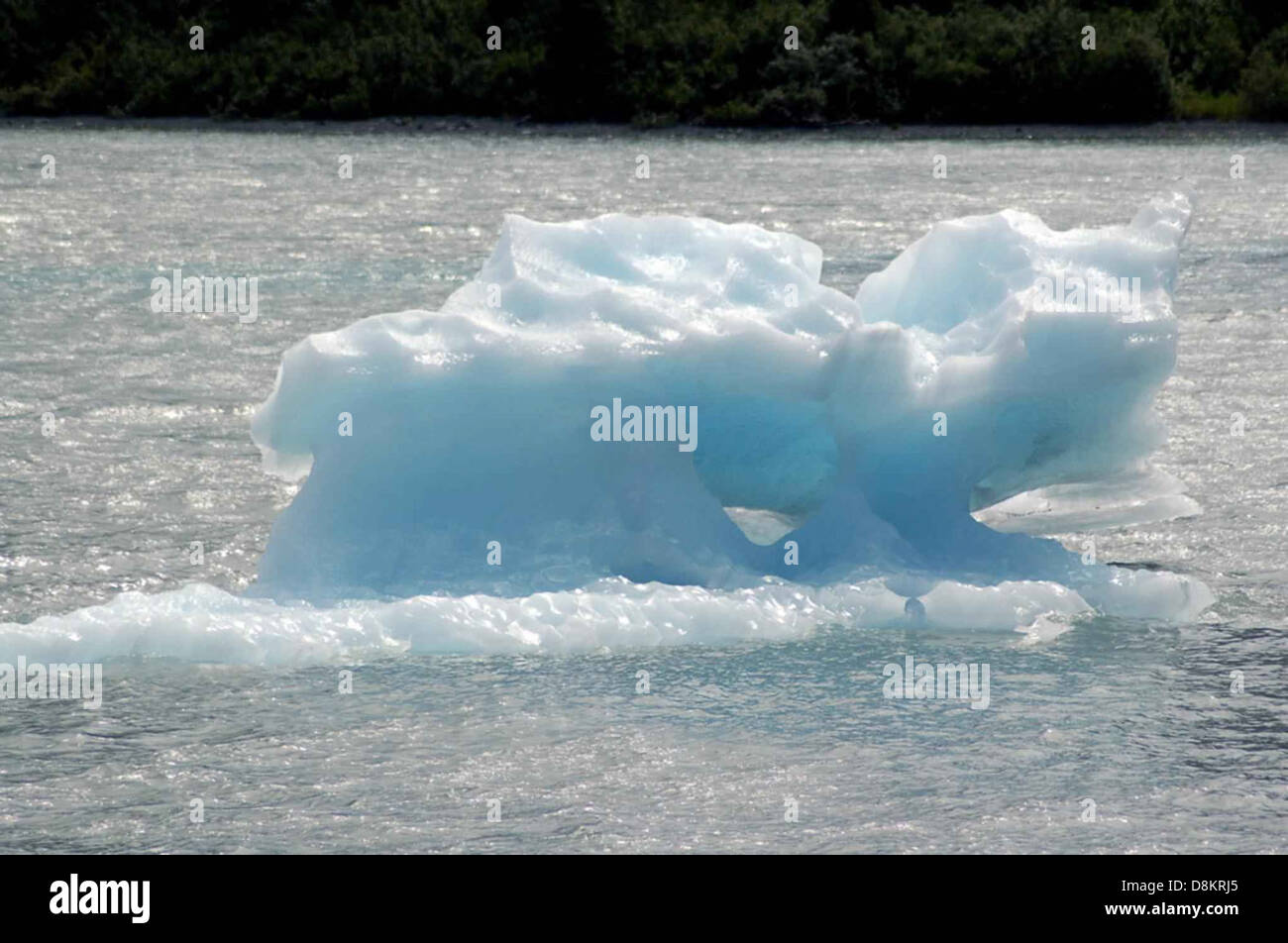 This image captures a large iceberg drifting in cold waters. The ice ...