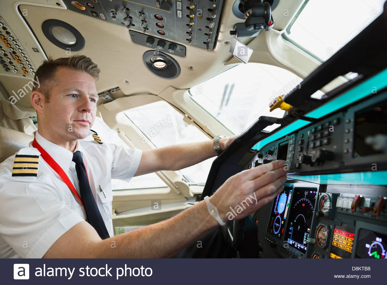 Male pilot checking control panel in airplane cockpit Stock Photo - Alamy