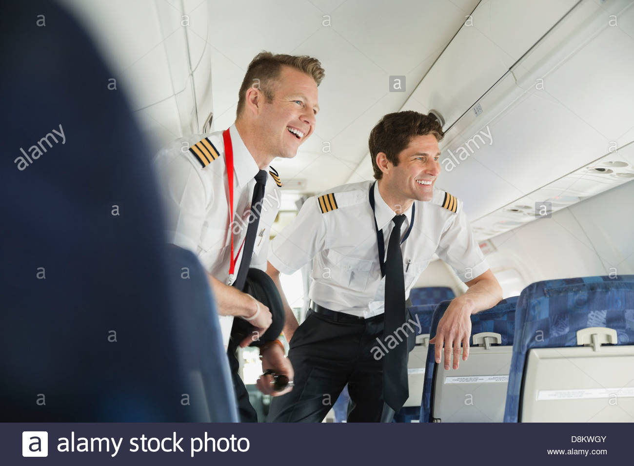 Male pilot and co-pilot looking out window in airplane cabin Stock ...