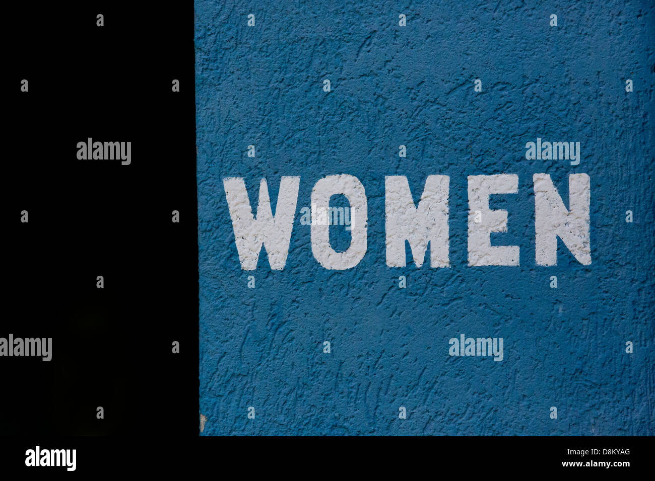 Word 'WOMEN' written on a bright blue wall Stock Photo - Alamy