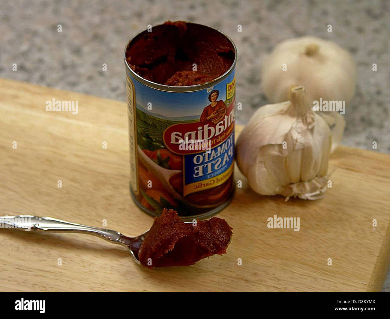 A collection of tomato paste cans arranged neatly on a surface. The ...