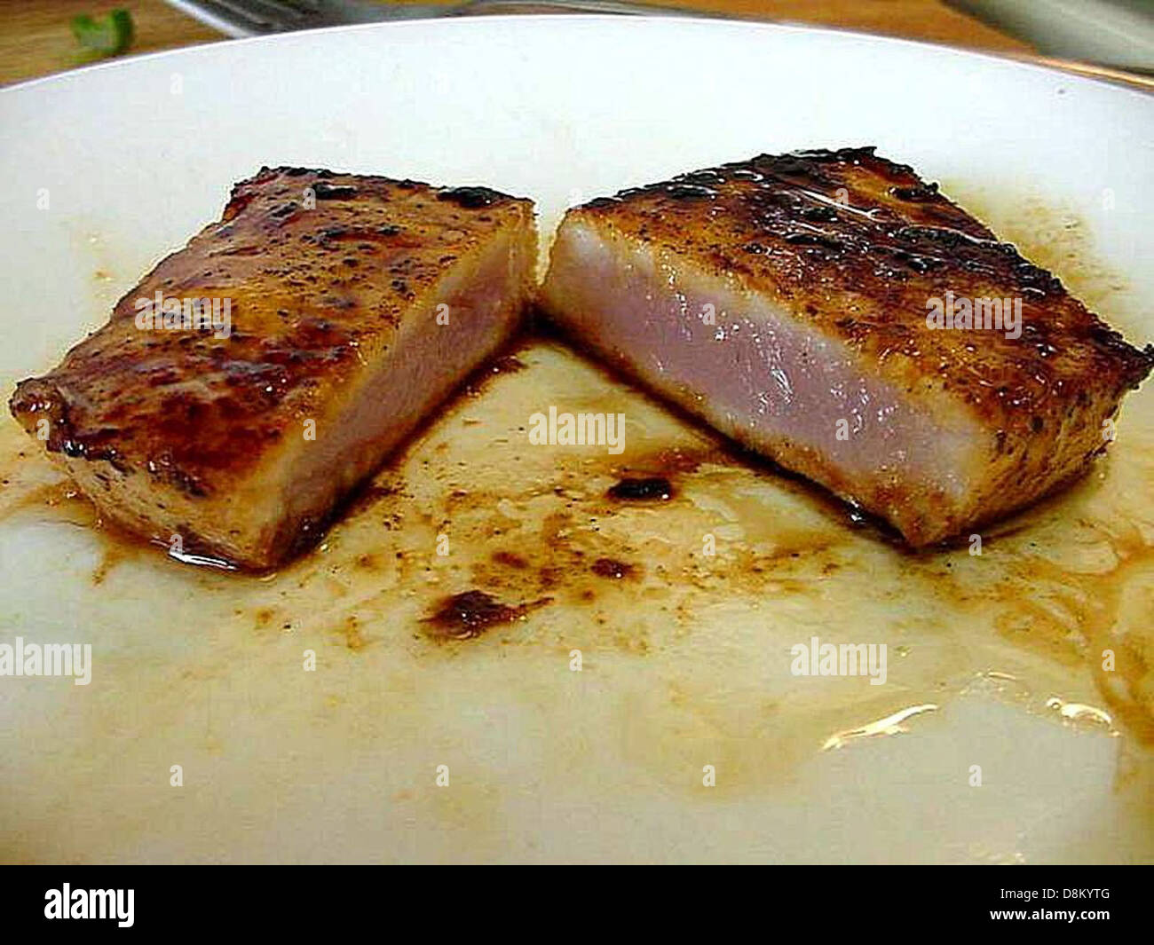 A plate with a serving of tuna, likely prepared as part of a meal. The ...