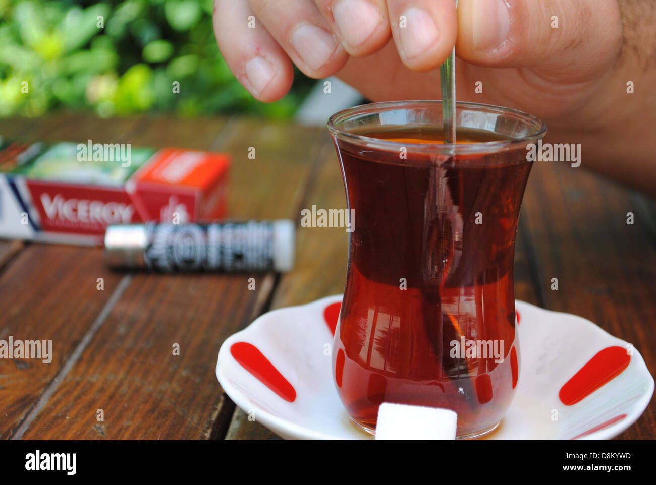 A traditional Turkish tea is presented in a tulip-shaped glass ...