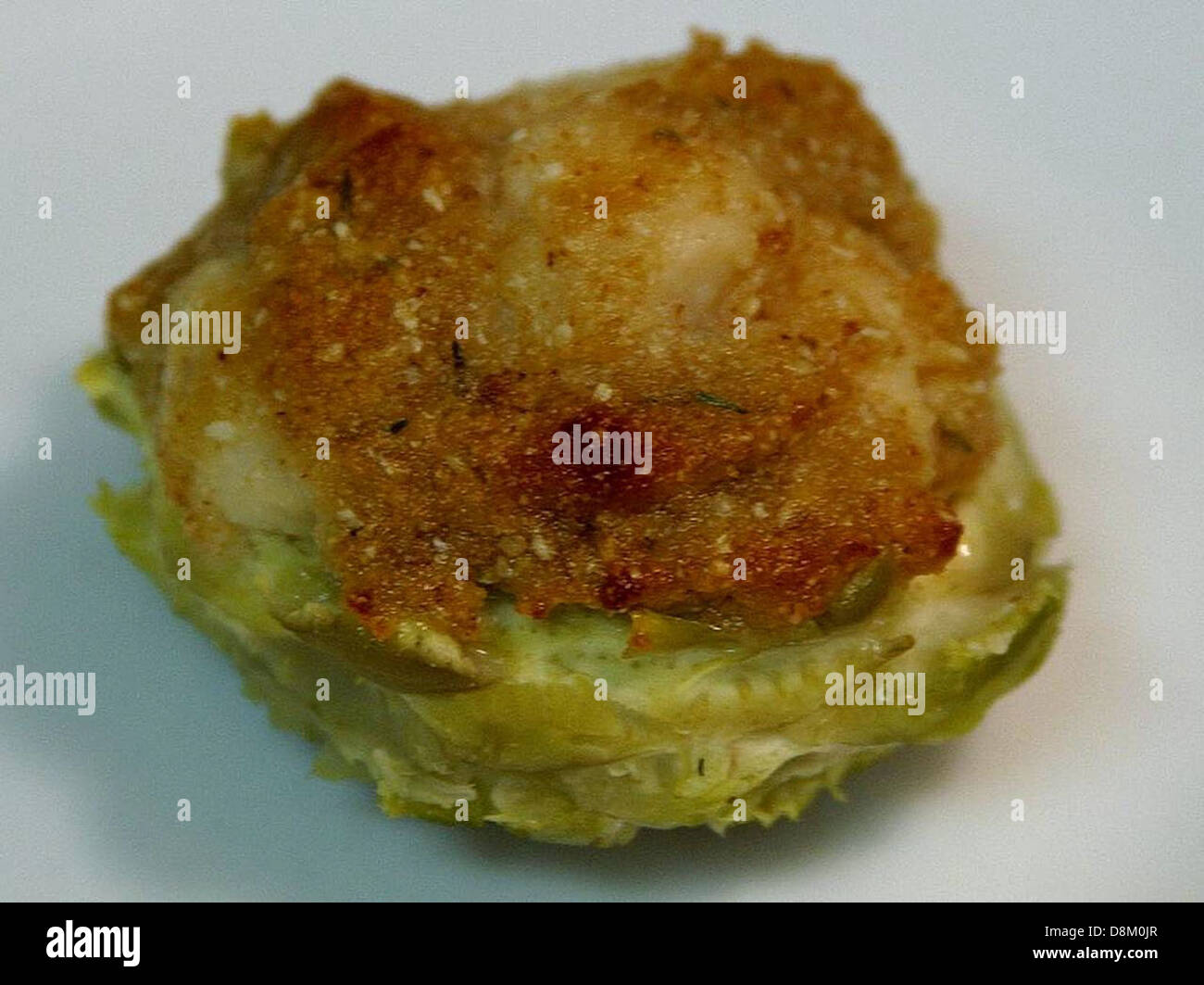Artichoke hearts filled with scallop stuffing, presented as a gourmet ...
