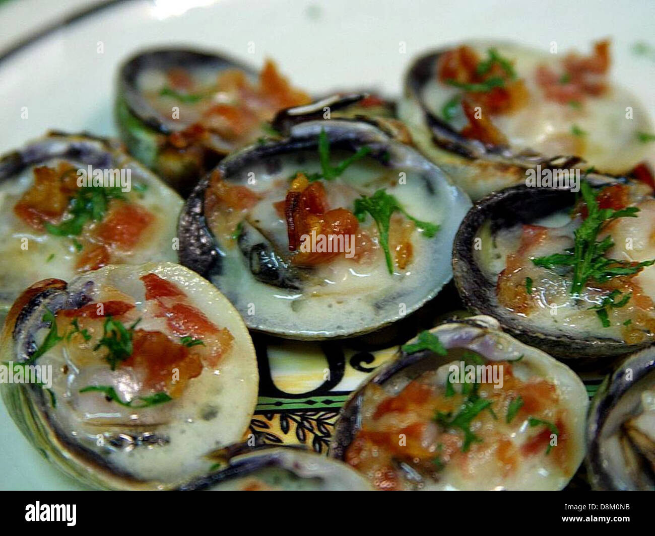 A gourmet dish featuring baked clams, paired with a champagne sauce and ...