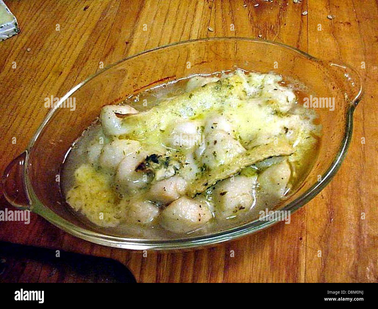 A plate of baked scallops, prepared with seasoning and herbs, showing ...