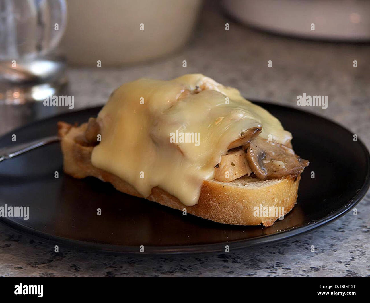 A plate of chicken marsala served on garlic toast, topped with melted ...
