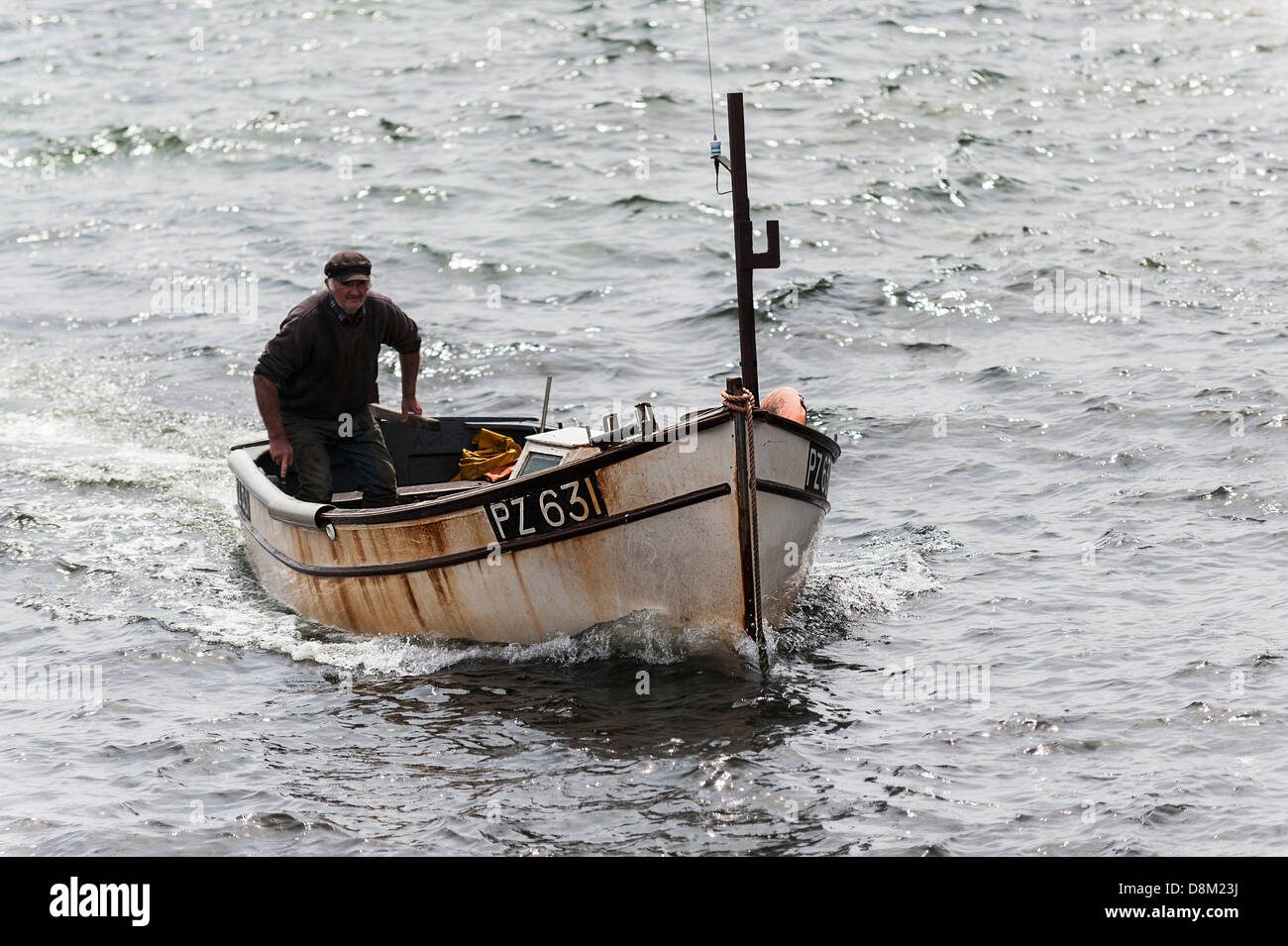 A Cornish fisherman steering his boat Stock Photo - Alamy
