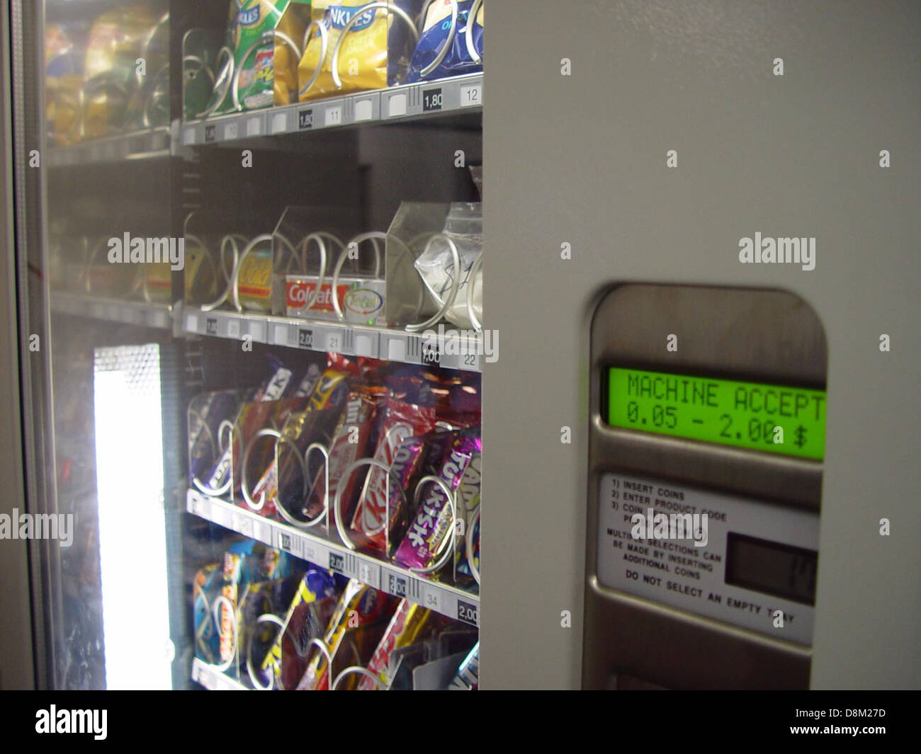 A food vending machine is shown, offering a variety of snacks and ...