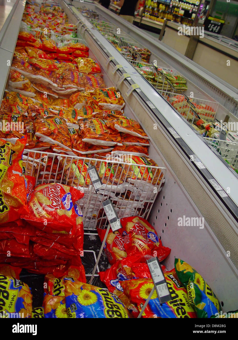 A freezer cabinet is stocked with various frozen food items. This image ...