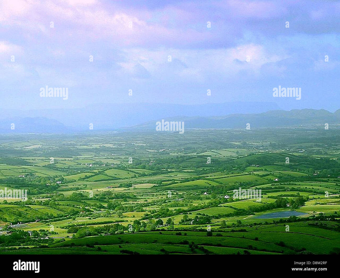 A broad view of green fields in Ireland, with rolling hills and ...