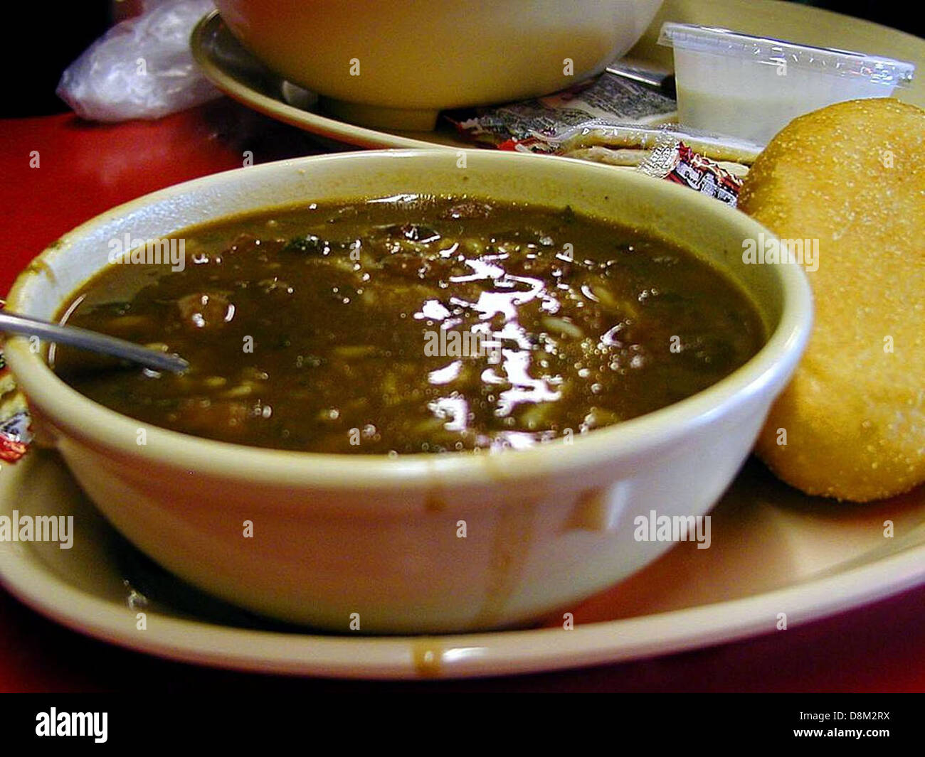 This stock photo shows bowls of gumbo with soft rolls on the side. The ...
