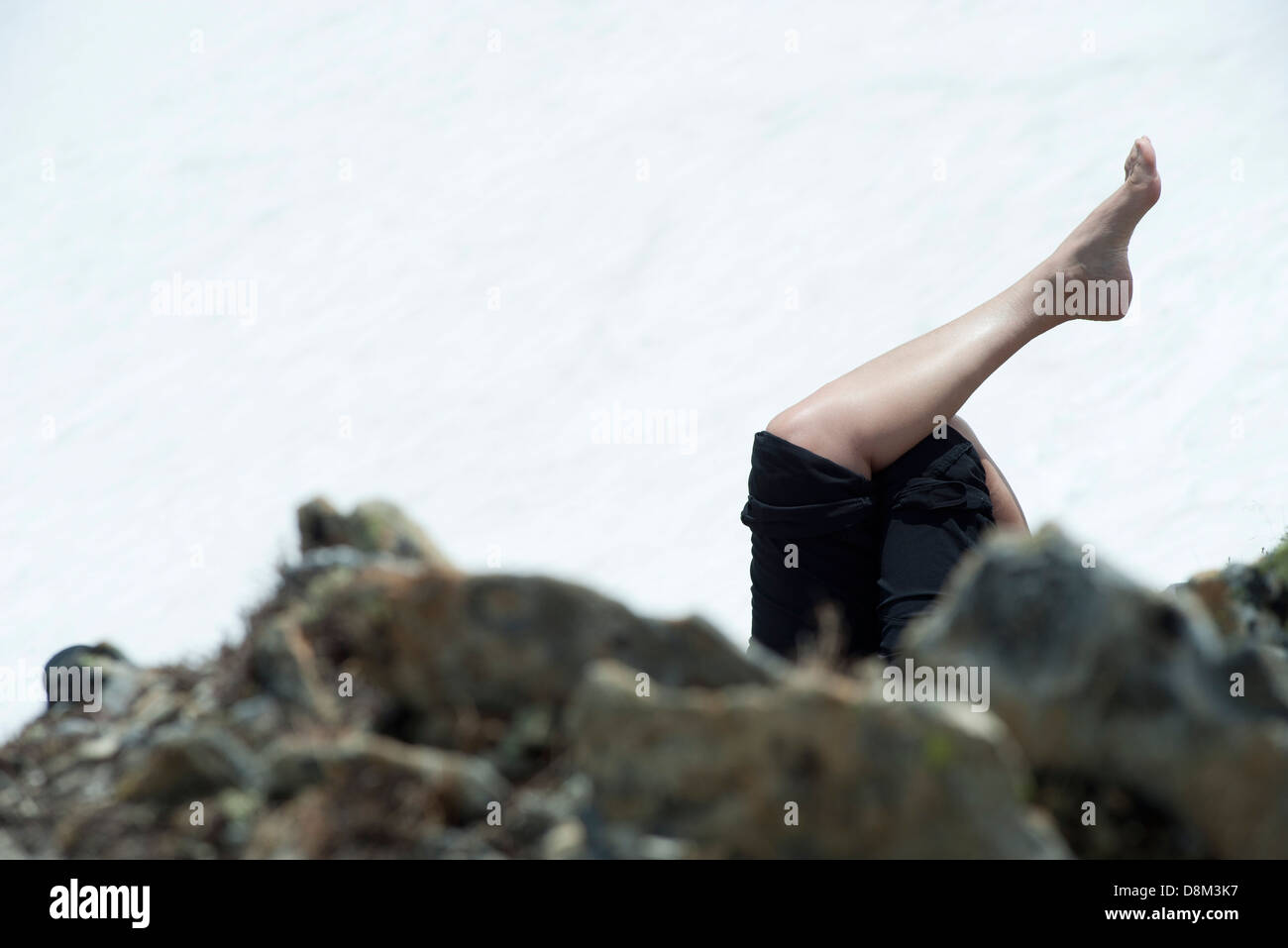 Woman lying on the ground with leg up, cropped Stock Photo - Alamy