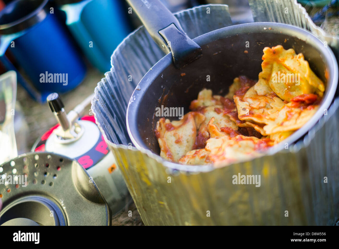 Cooking pasta on a small stove while camping wild in a tent Stock Photo ...