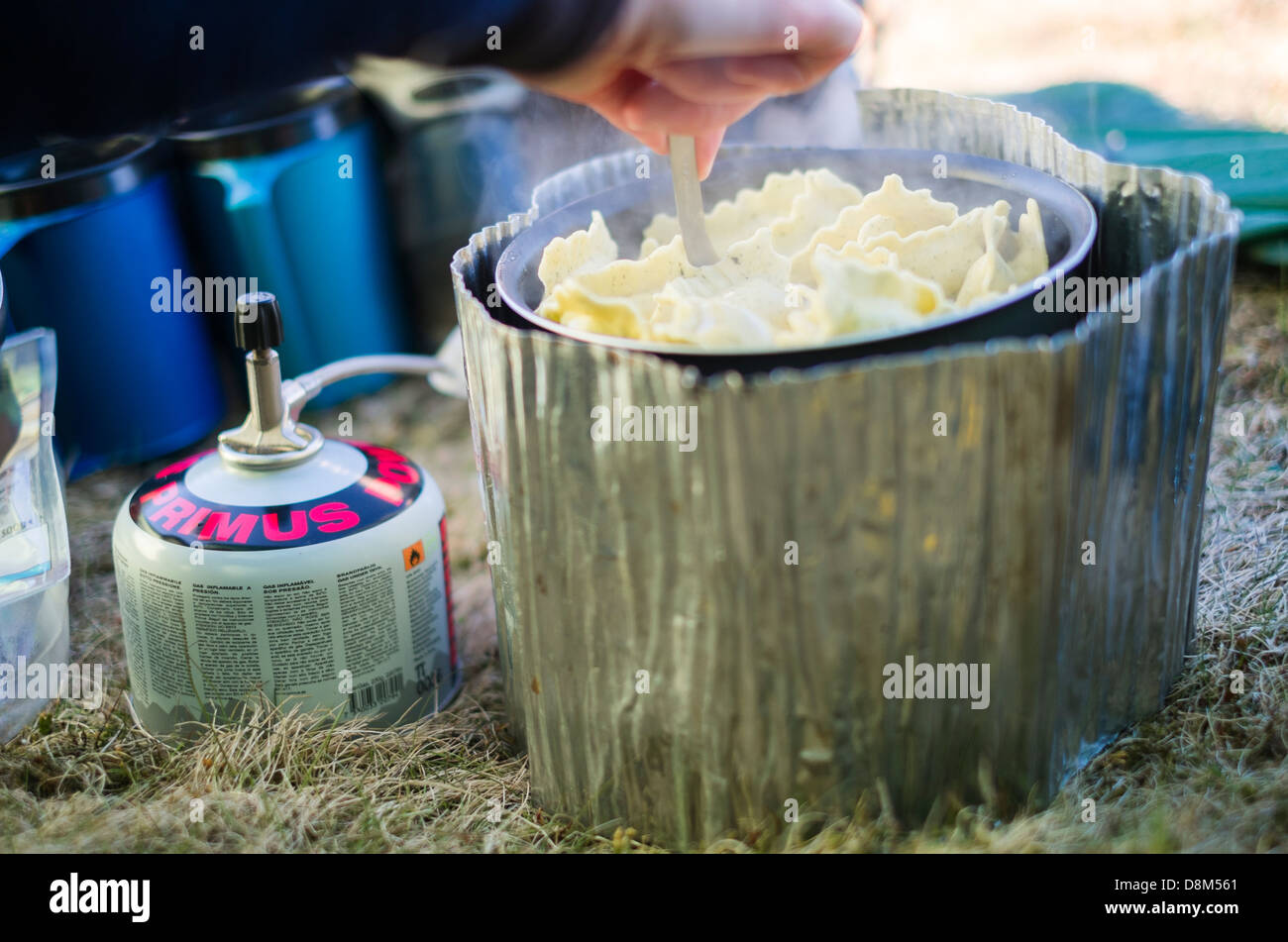Cooking pasta on a small stove while camping wild in a tent Stock Photo ...