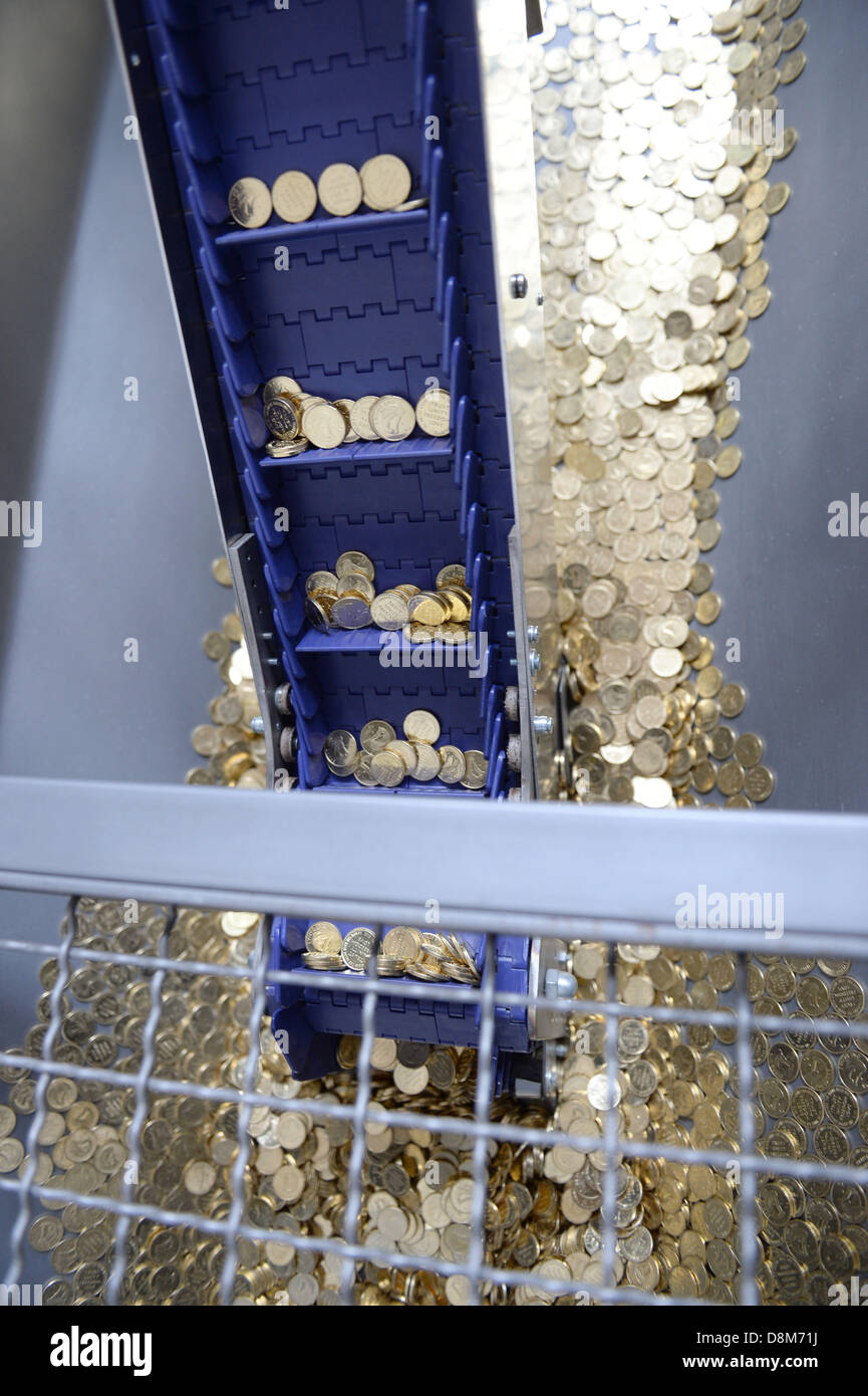 Golden coins are transported on a band conveyor in the contribution ...