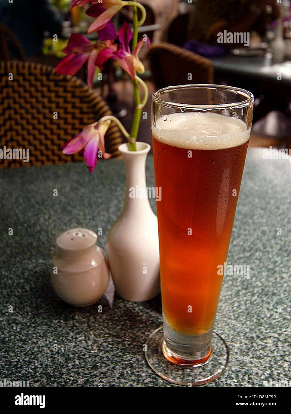 A clear beer glass filled with a refreshing beverage. The glass ...