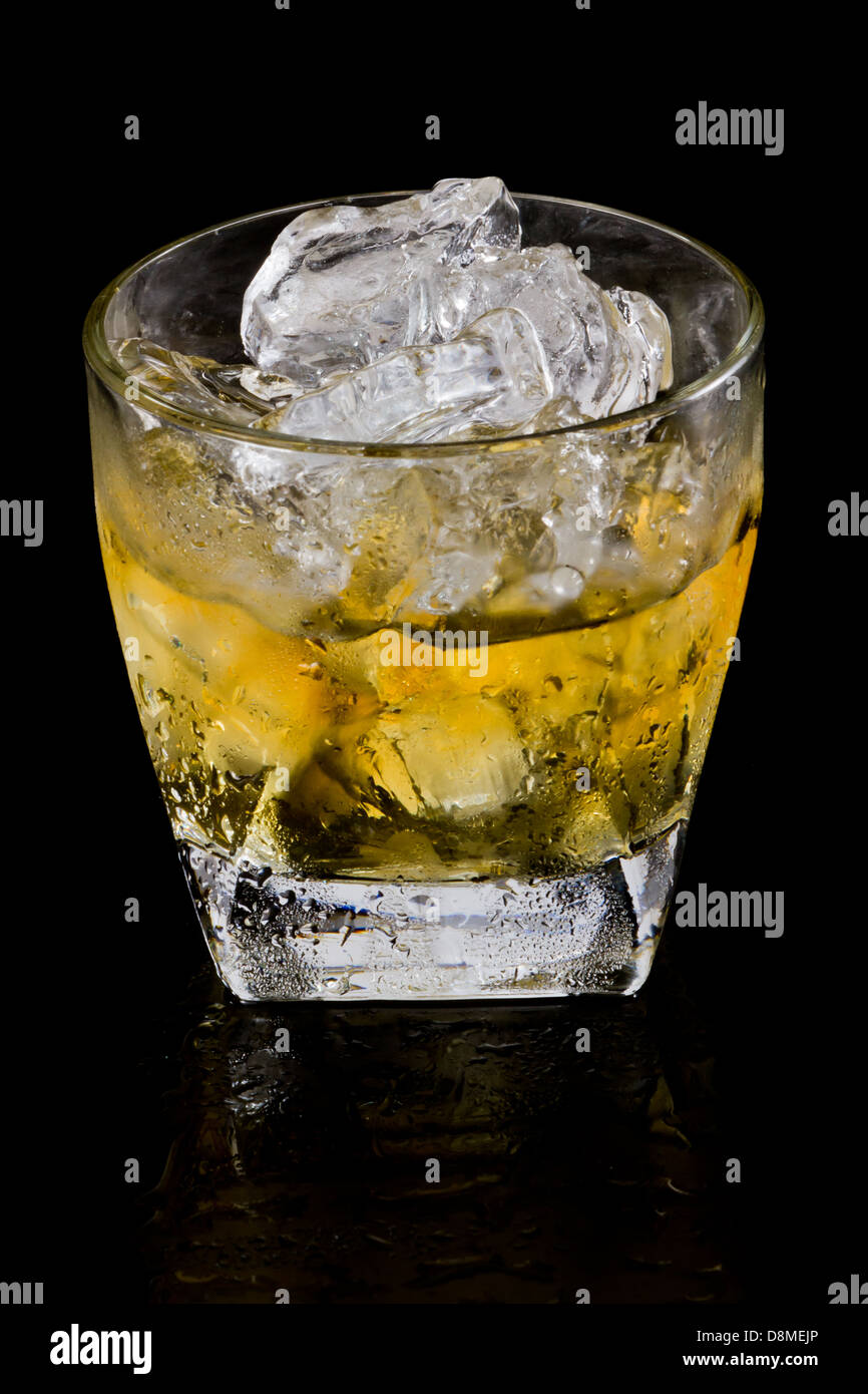 glass of whiskey over ice served on a dark bar Stock Photo - Alamy