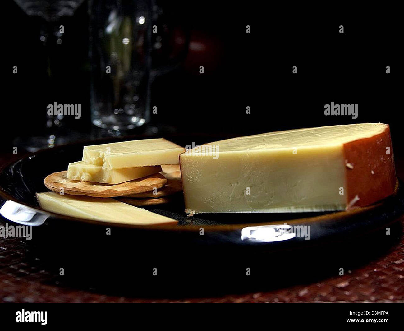 A round wheel of smoked gouda cheese, featuring a smooth, golden-brown ...