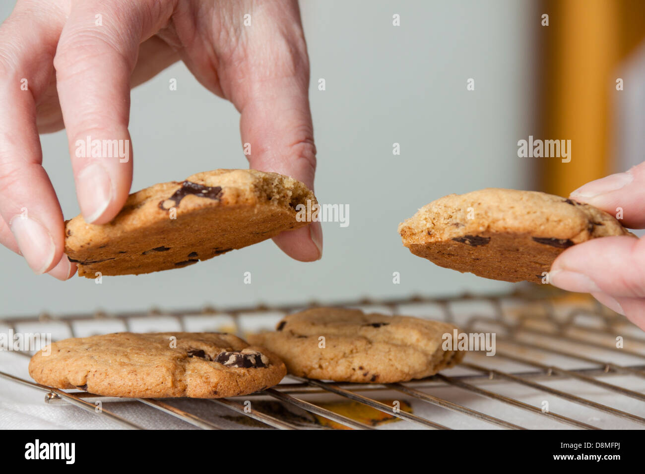 Woman's hands taking cookies off cooling rack Stock Photo - Alamy