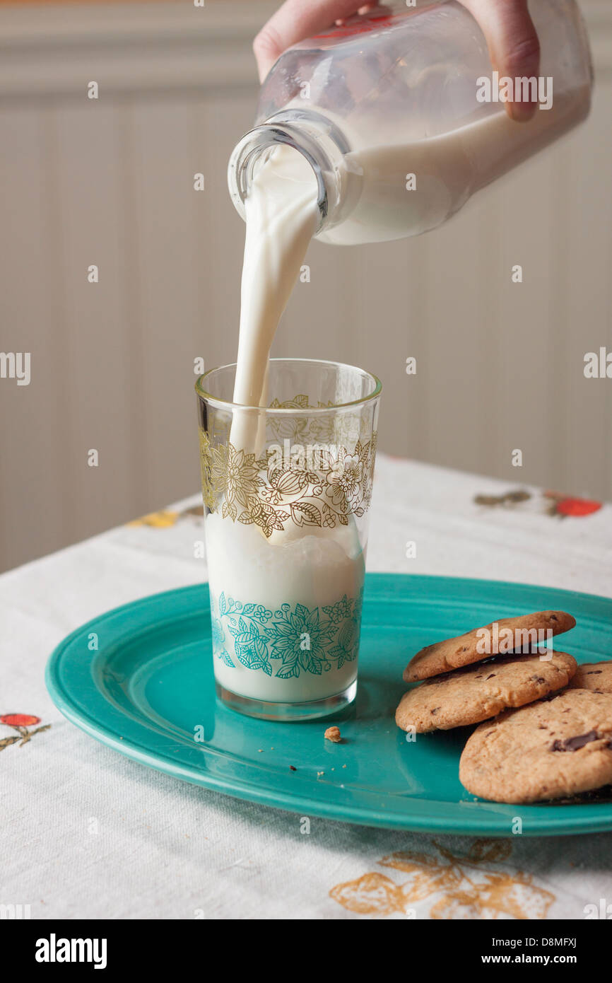 Pouring cold milk with delicious chocolate chip cookes Stock Photo - Alamy