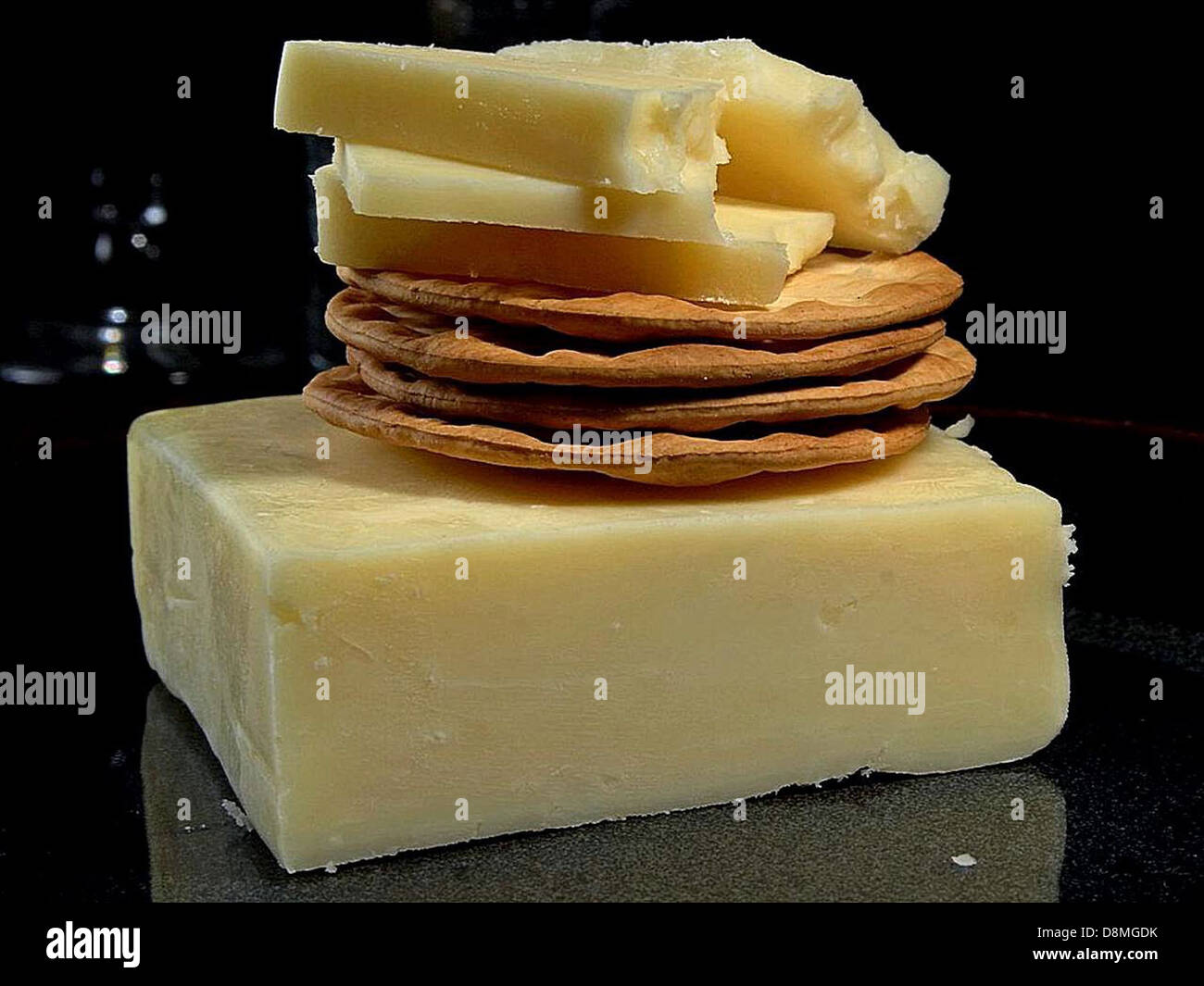 This image shows a block of white cheddar cheese. The cheese is ...