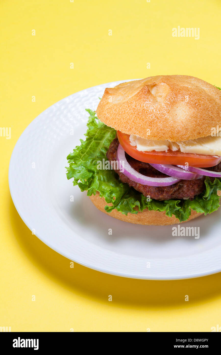 Cheeseburger isolated on yellow background, vertical Stock Photo - Alamy
