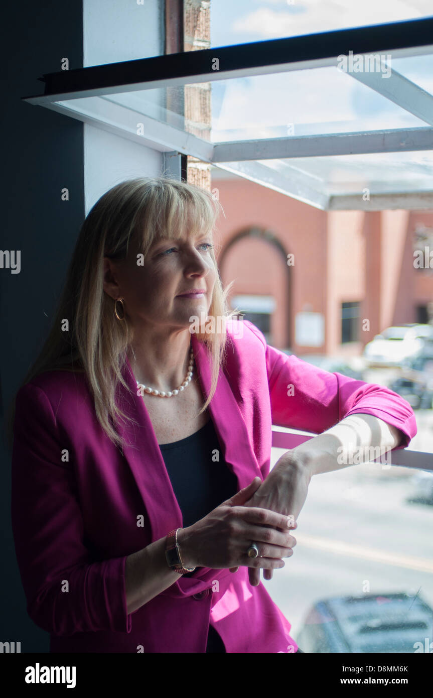 Woman standing at window Stock Photo - Alamy