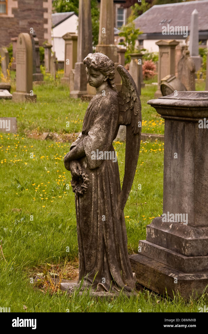 Female Angel statue beside a large tombstone inside the grounds of a ...