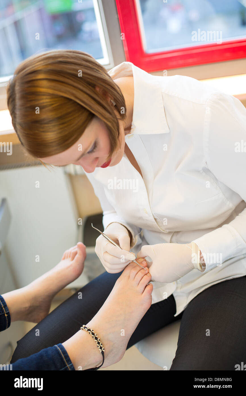 Pedicure at work in salon caring for customers foot nails Stock Photo ...