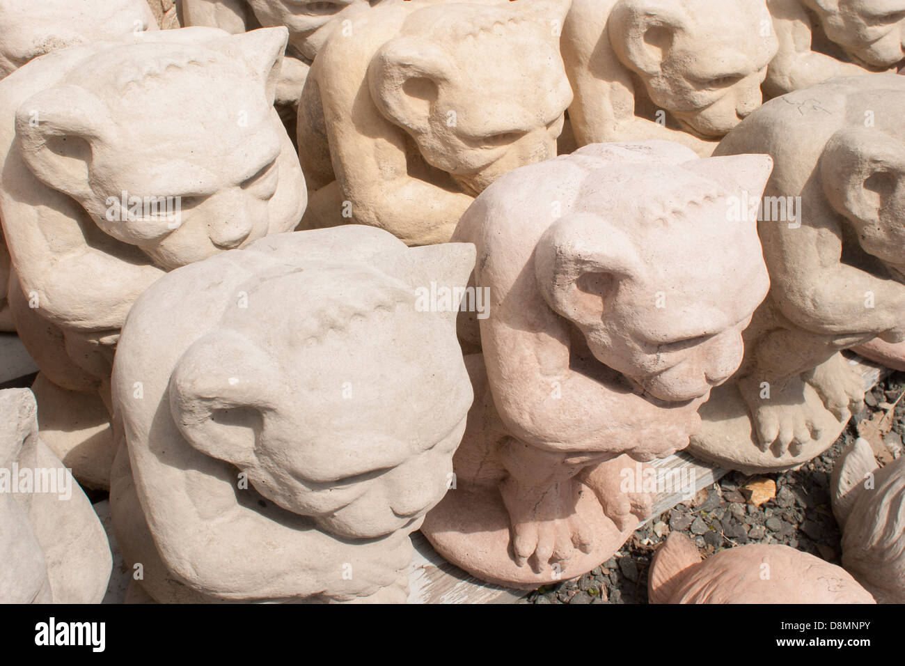 Brooding gargoyle figurines are lined up for sale at a roadside ...