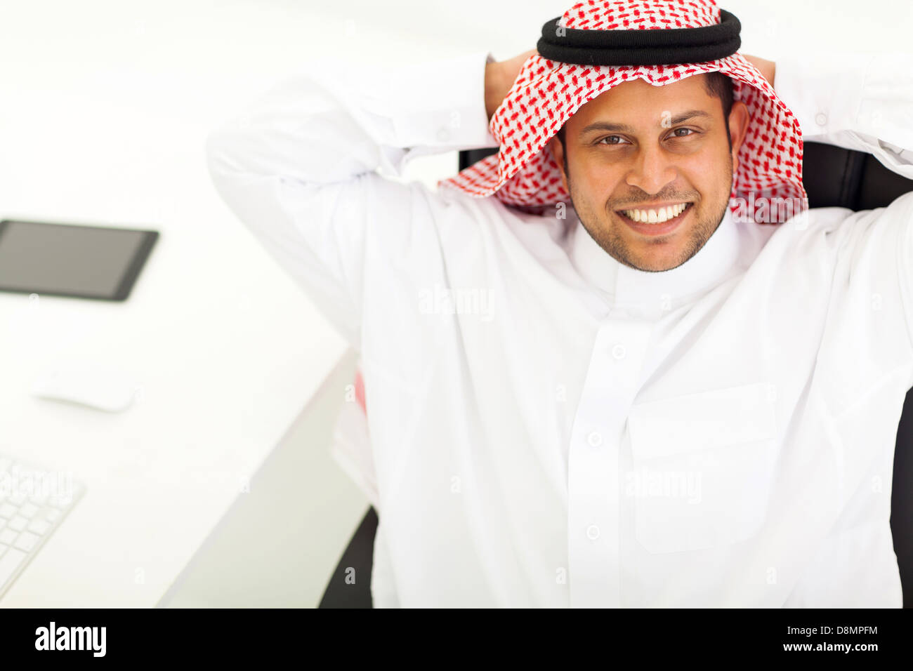 above view of smiling middle eastern businessman relaxing in office ...