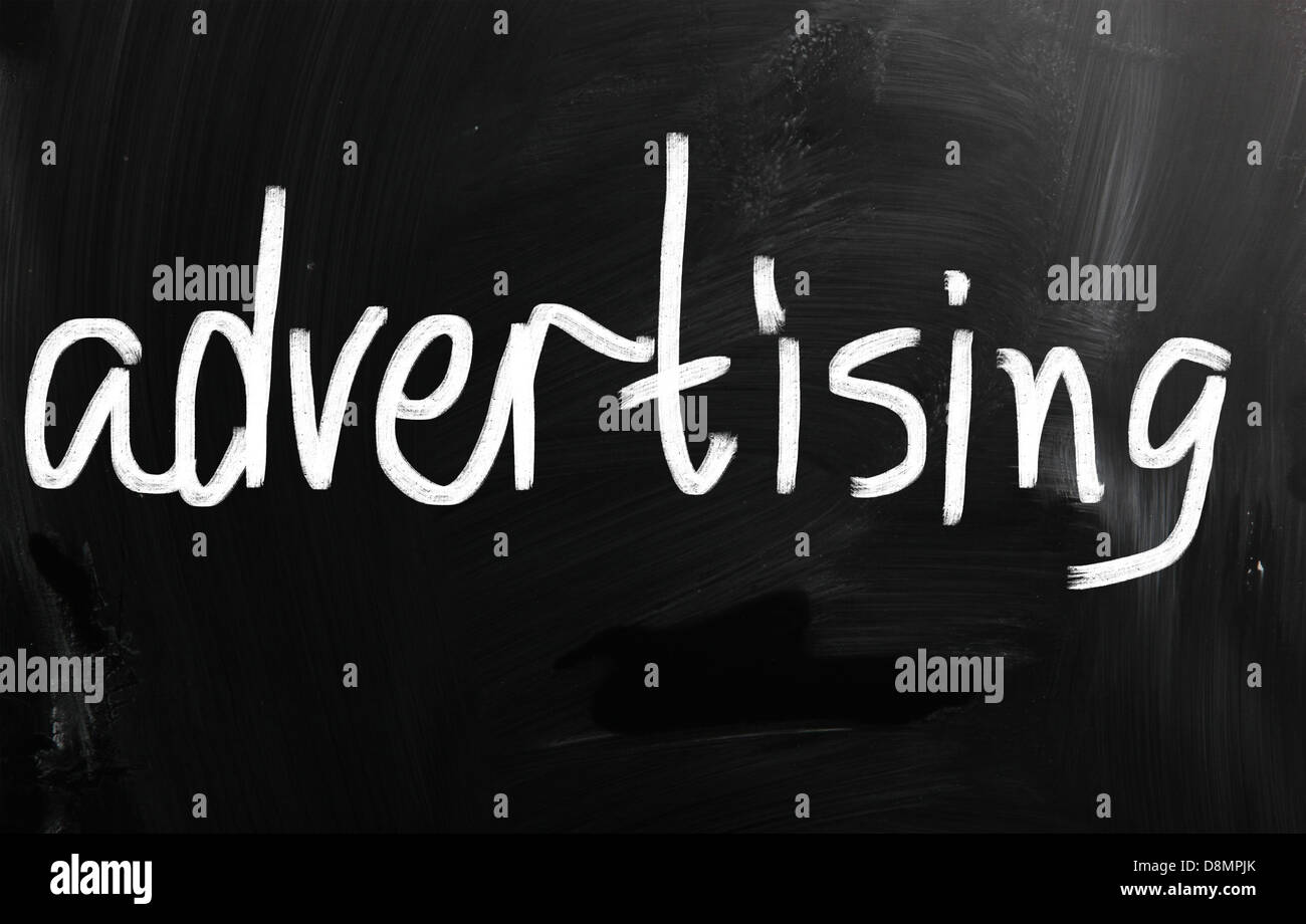 The word "advertising" handwritten with white chalk on a blackboard ...