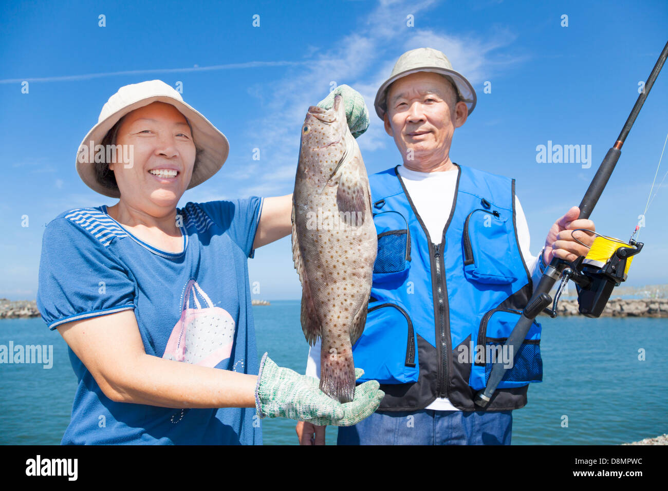 happy senior couple fishing and showing big grouper Stock Photo - Alamy
