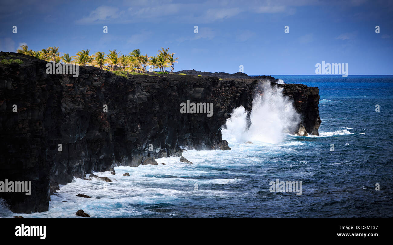 Waves crash along the black lava rock cliffs in the Hawaiian Volcanoes ...