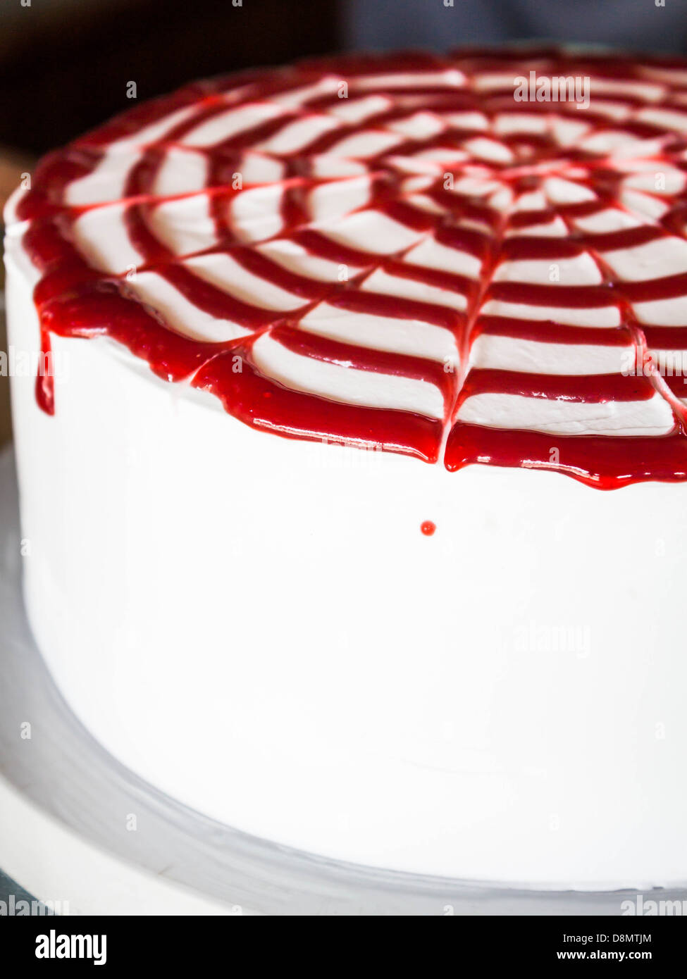 Raspberry sauce topped white whipped cream cake Stock Photo - Alamy