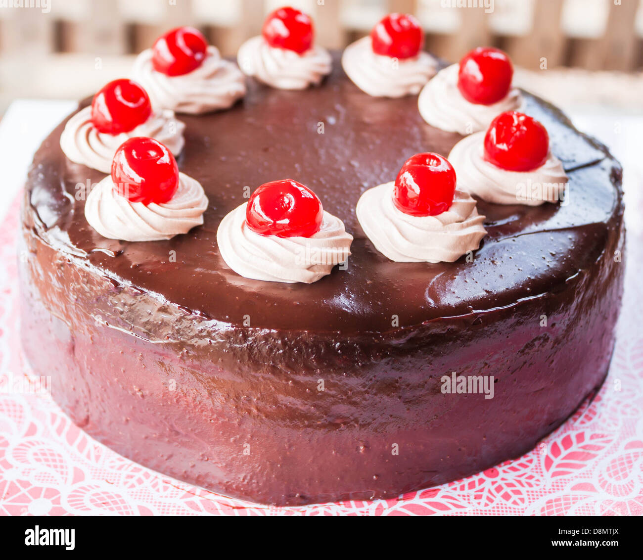 Delicious chocolate cake with red cherry on top Stock Photo - Alamy