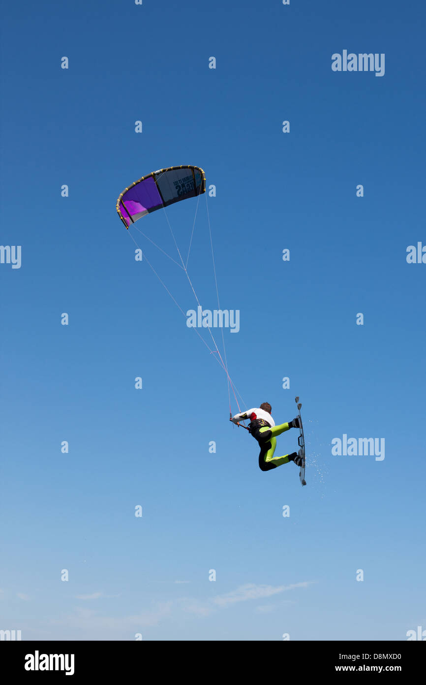 Kitesurfer flying high up in the air against a blue sky. Cannes, French ...