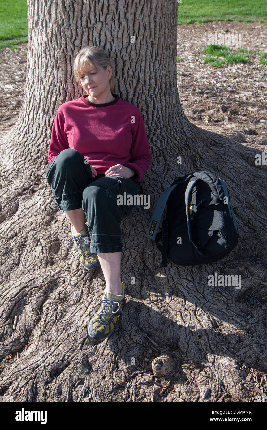 Woman sitting on a tree's above-ground roots Stock Photo - Alamy