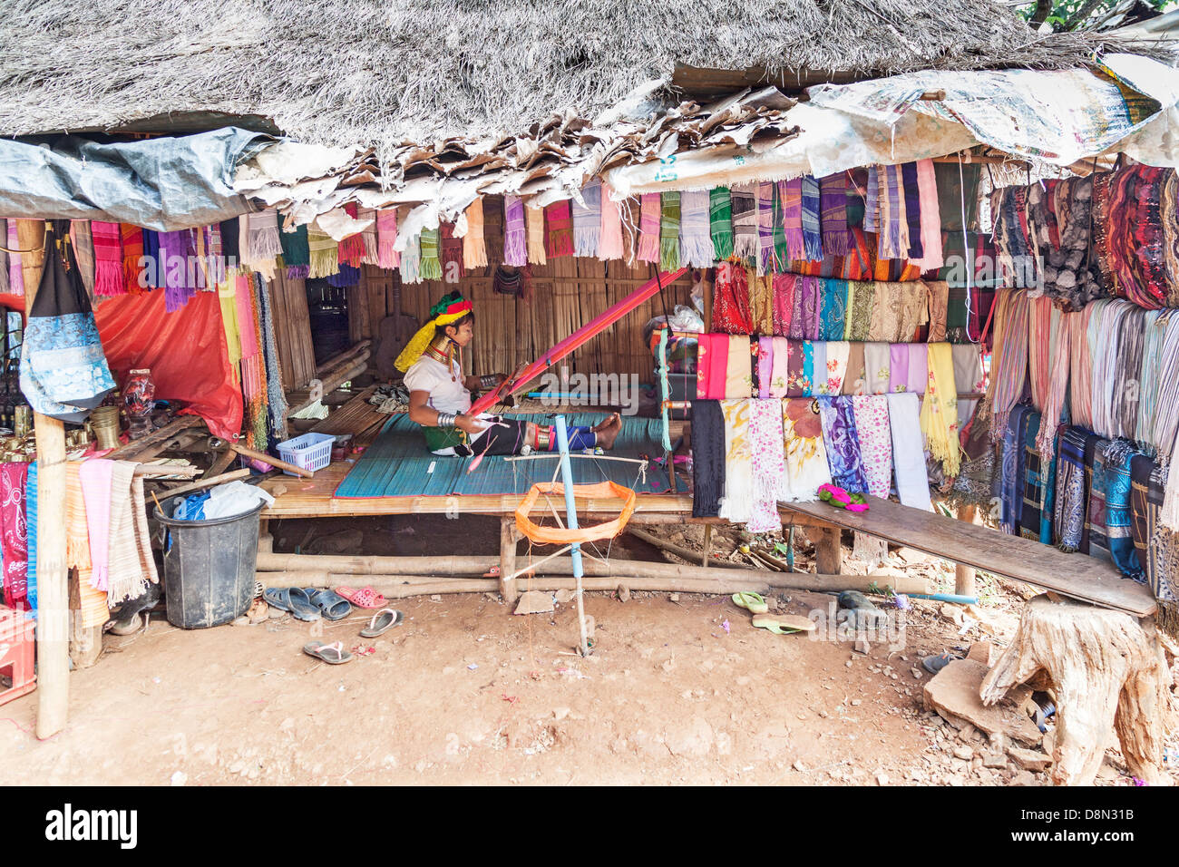Karen Padong tribeswoman weaving in hut in a village near Chiang Rai ...