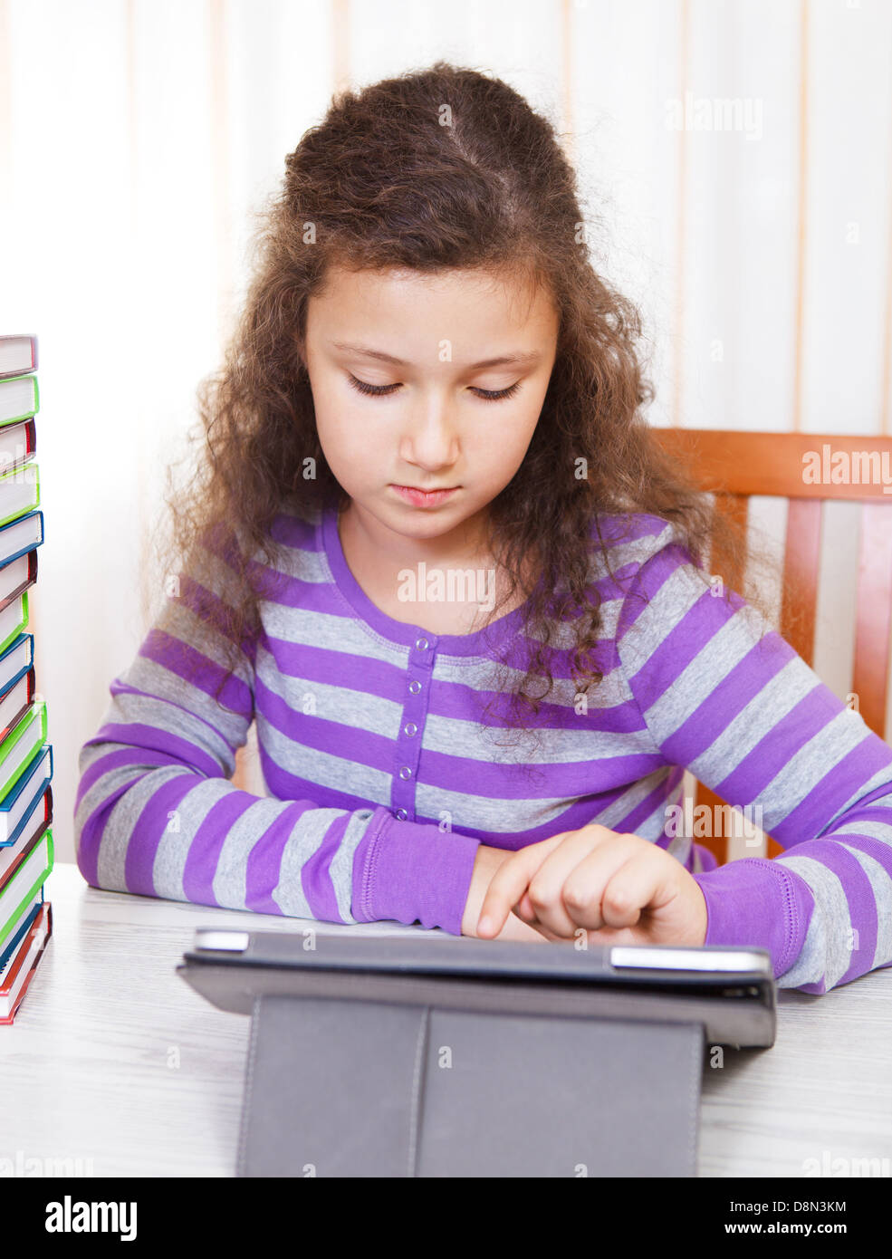 Little brunette girl using tablet computer Stock Photo - Alamy